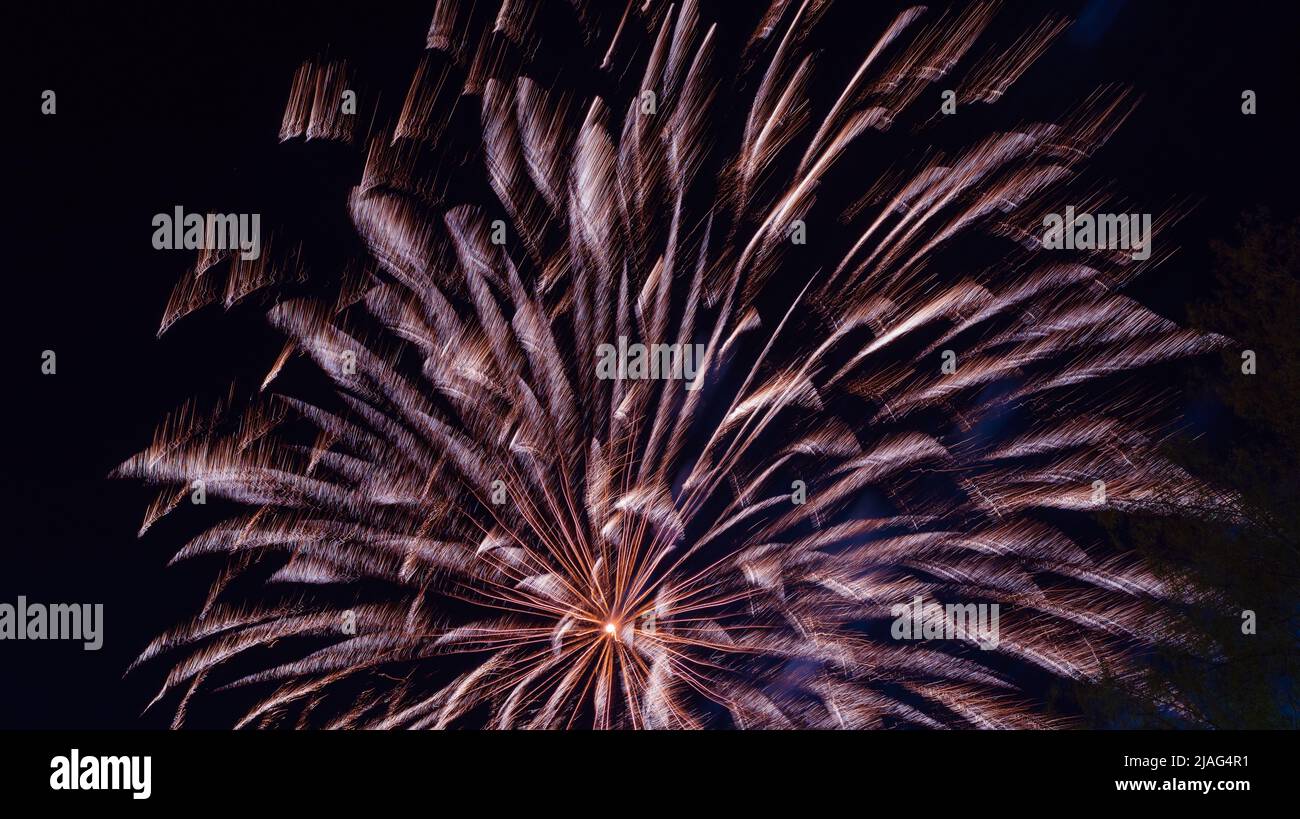 Large and bright festive yellow fireworks in the night sky. High ...