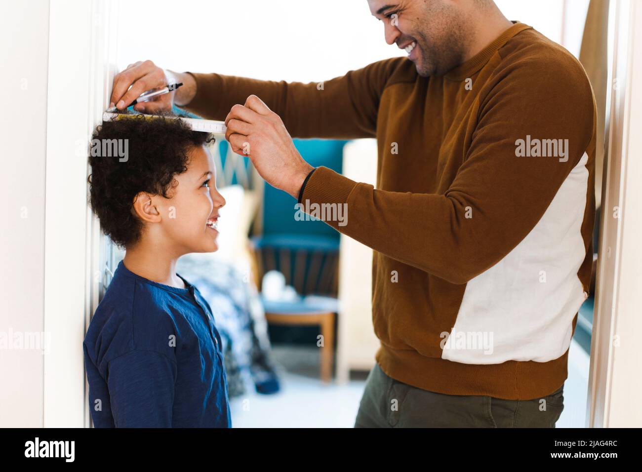 Happy father measuring height of son at doorway of home Stock Photo - Alamy