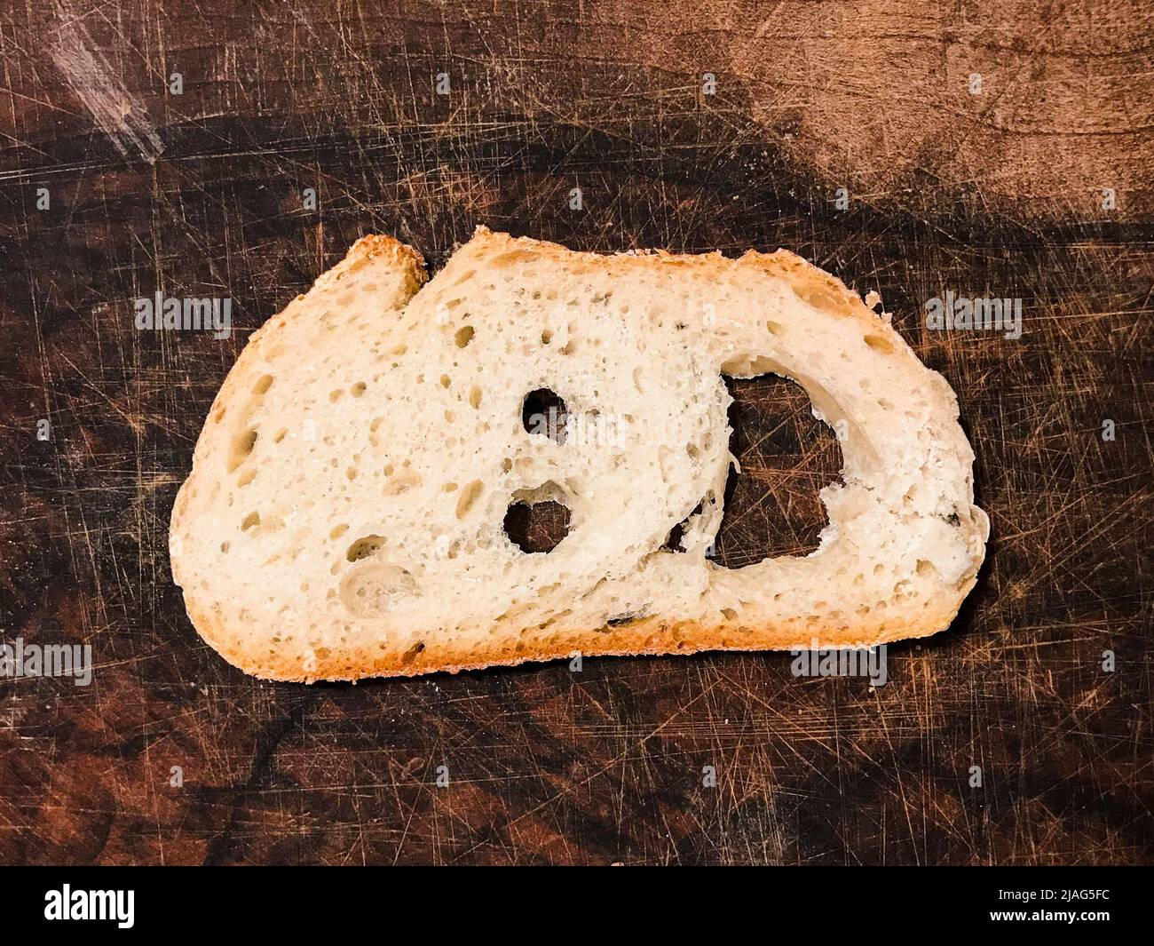 Slice of rustic rustic white bread in the shape of a smiling face on in ...