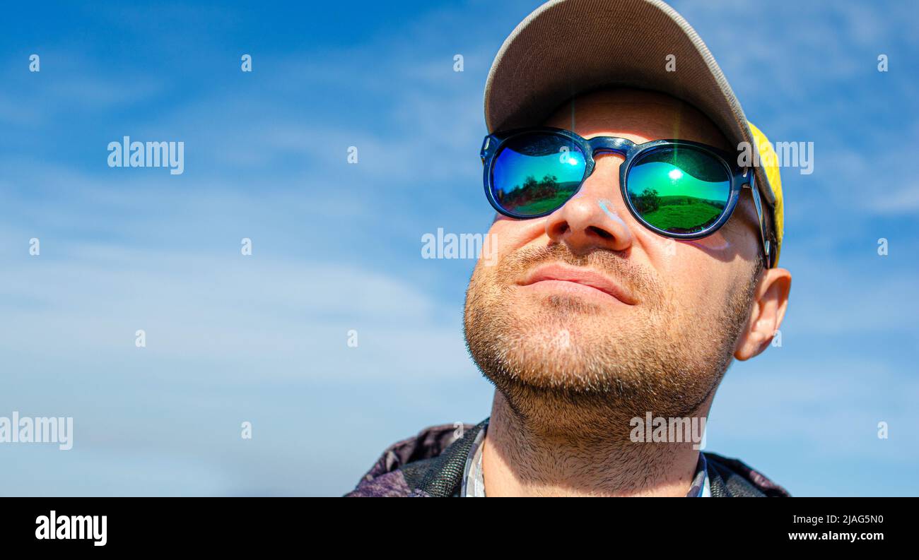 A young man in a cap and glasses Stock Photo - Alamy