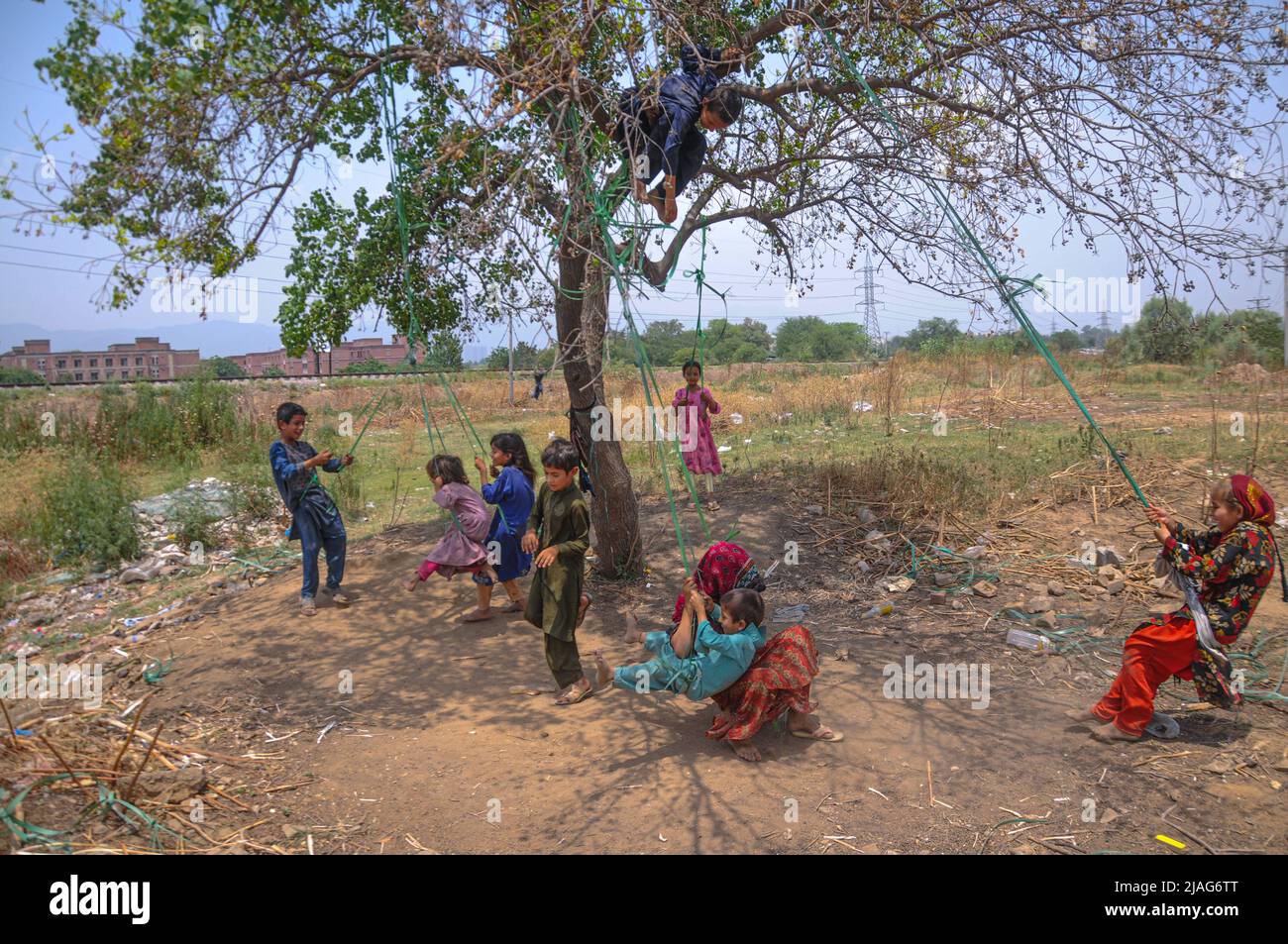 Afghan refugee children play on a local swing in a suburb of Islamabad ...