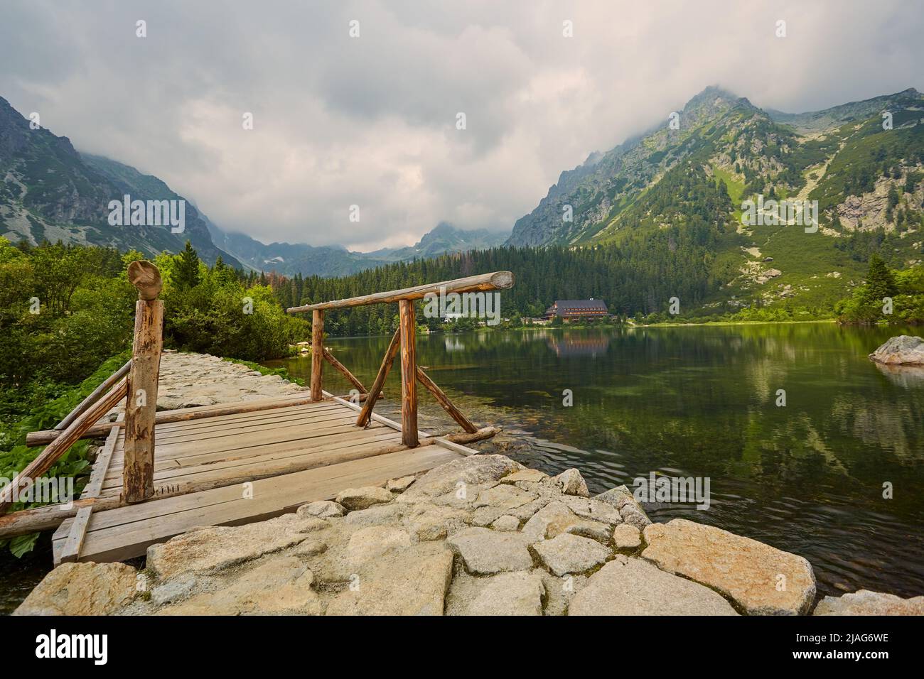 Stone path high in mountains near lake. Wooden bridge. High and steep ...