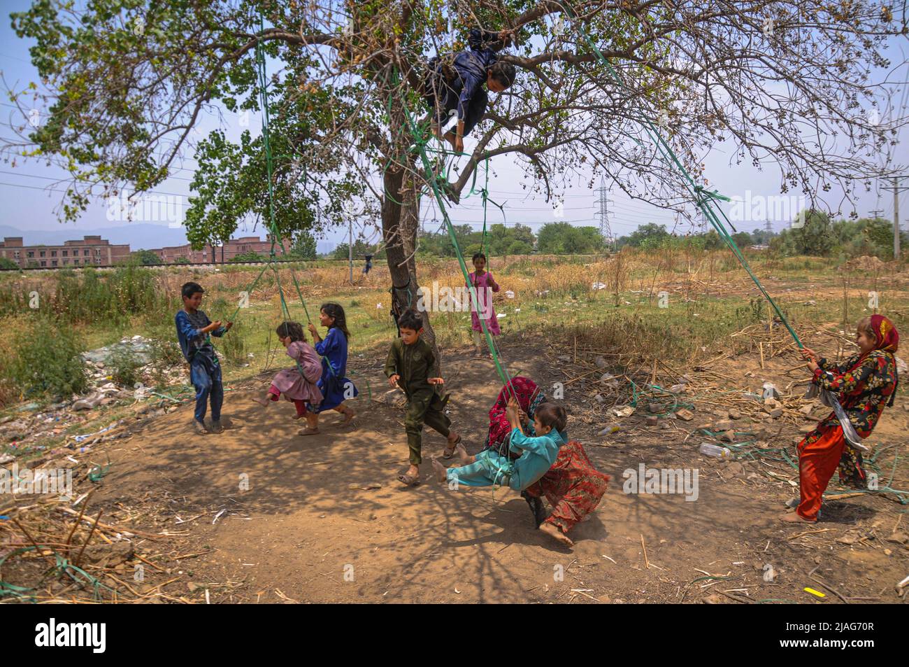 Afghan refugee children play on a local swing in a suburb of Islamabad ...