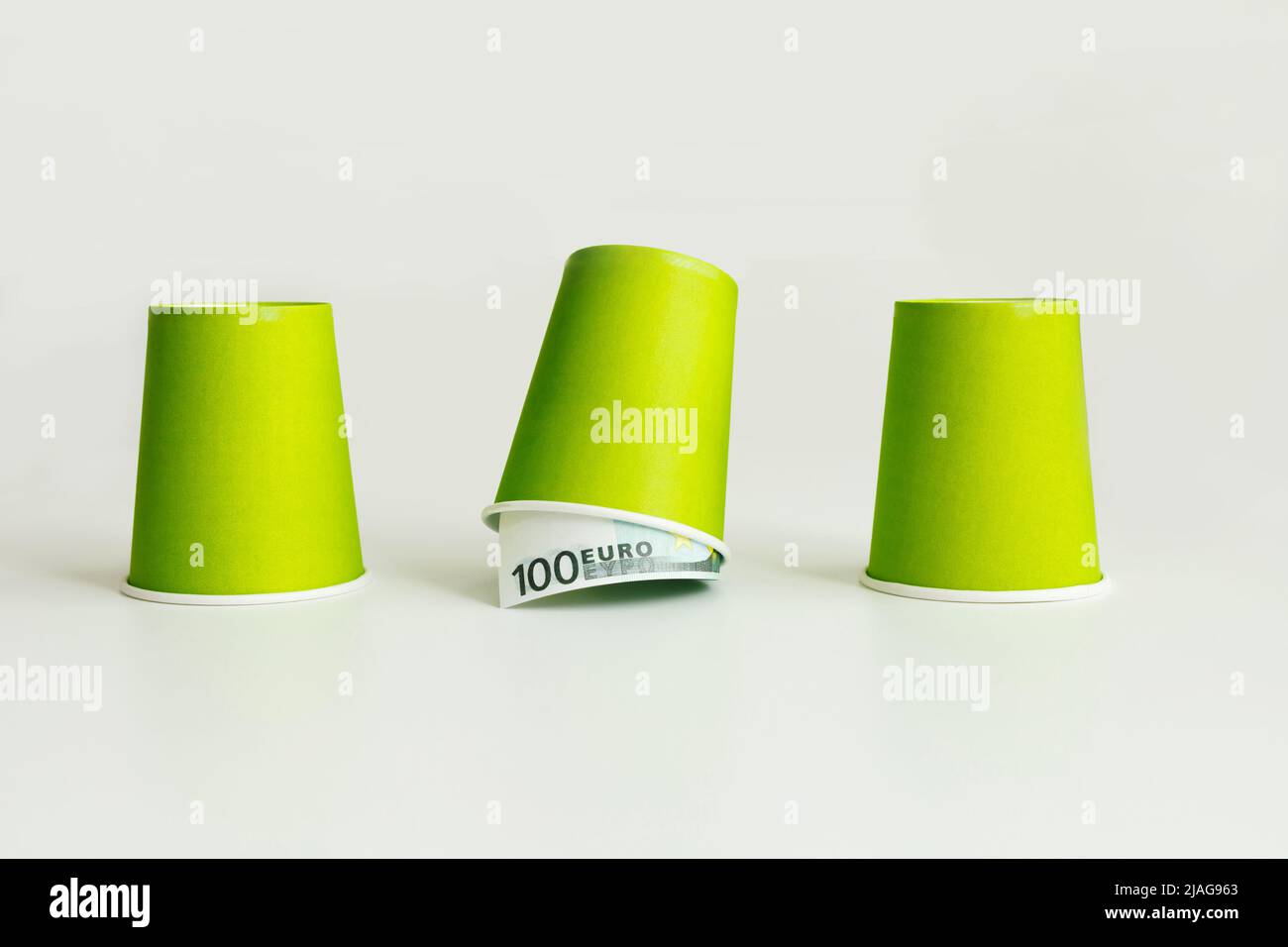 Euro banknote under open paper cup in a game of shells Stock Photo - Alamy