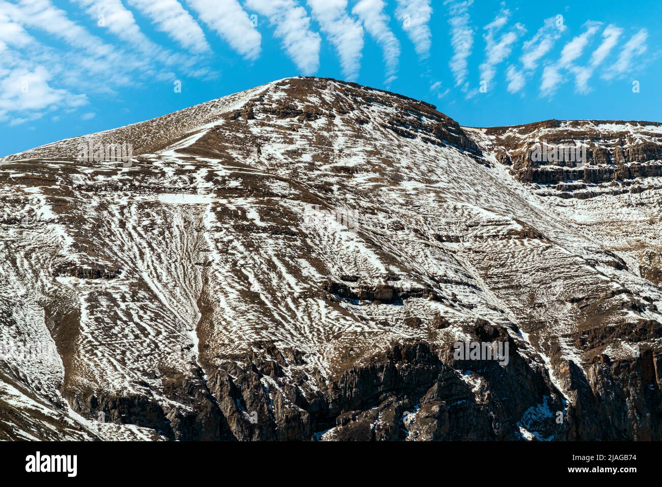 Rocky snowy mountain peak and sky Stock Photo - Alamy