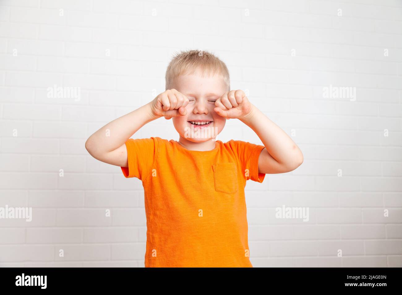 Little European boy wakes up and rubs eyes Stock Photo - Alamy