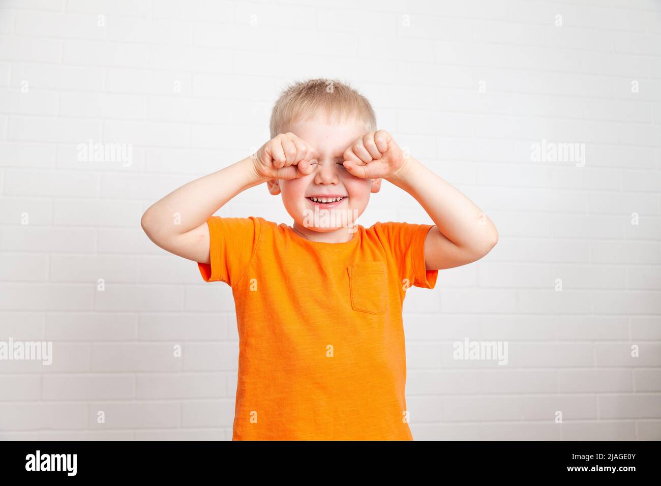 Little European boy wakes up and rubs eyes Stock Photo - Alamy