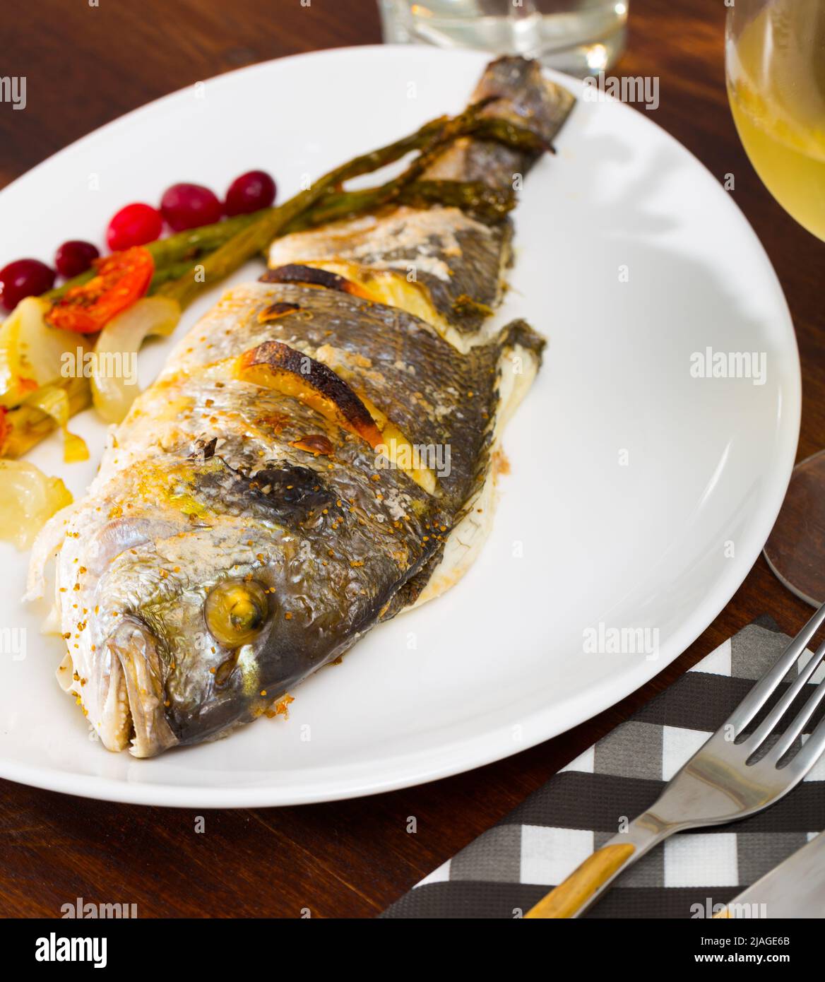 Roasted dorada with baked vegetables and cranberries Stock Photo - Alamy