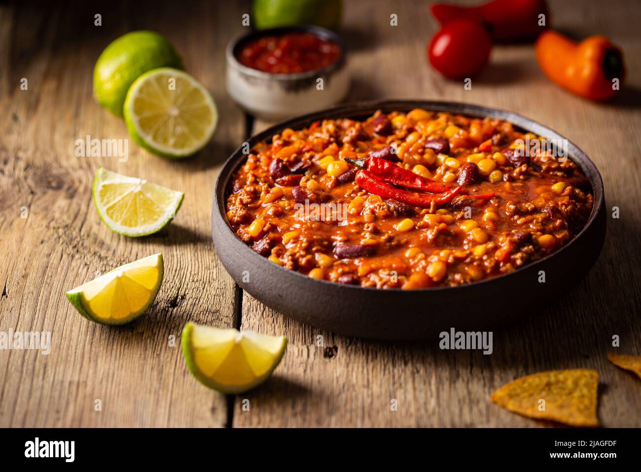 Mexican hot chili con carne in a bowl with tortilla chips on wooden ...