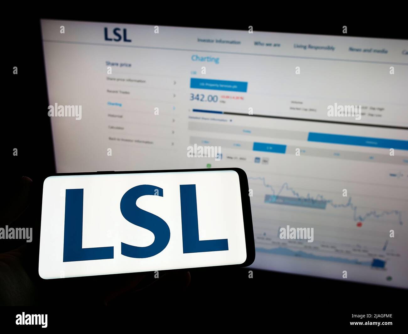 Person holding mobile phone with logo of British company LSL Property ...