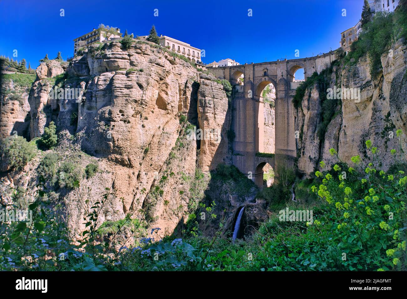 Ronda, Malaga, Spain - Brilliant yellow spring flowers and waterfall at ...