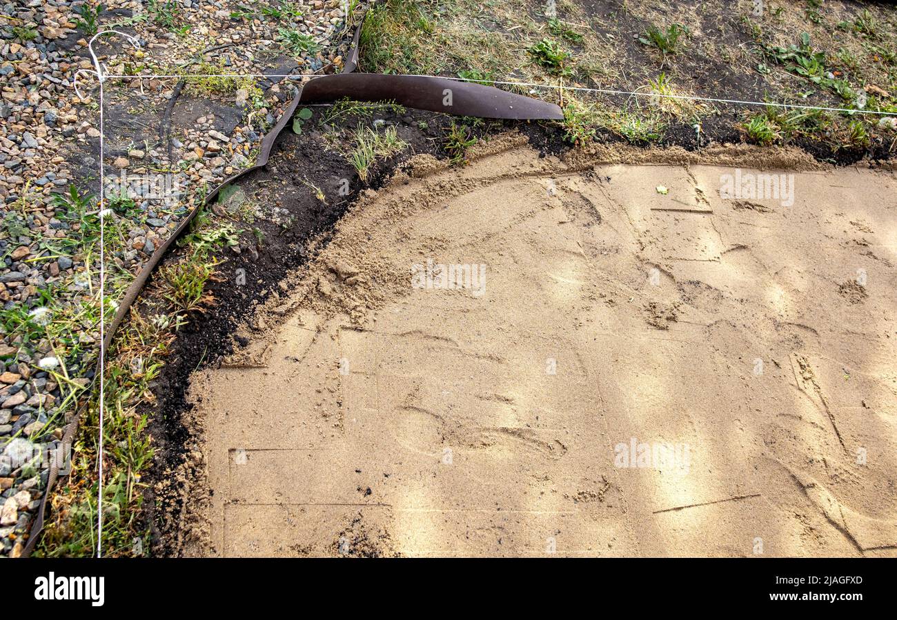 The boundary between wet sand and crushed stone with pebbles on the ...
