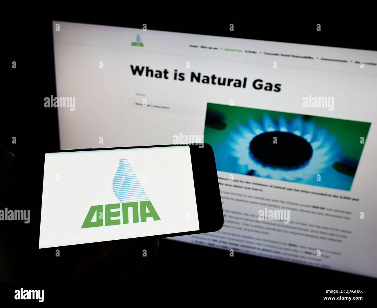 Person holding cellphone with logo of Greek energy company DEPA ...