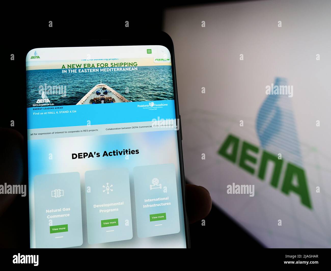 Person holding smartphone with website of Greek energy company DEPA ...