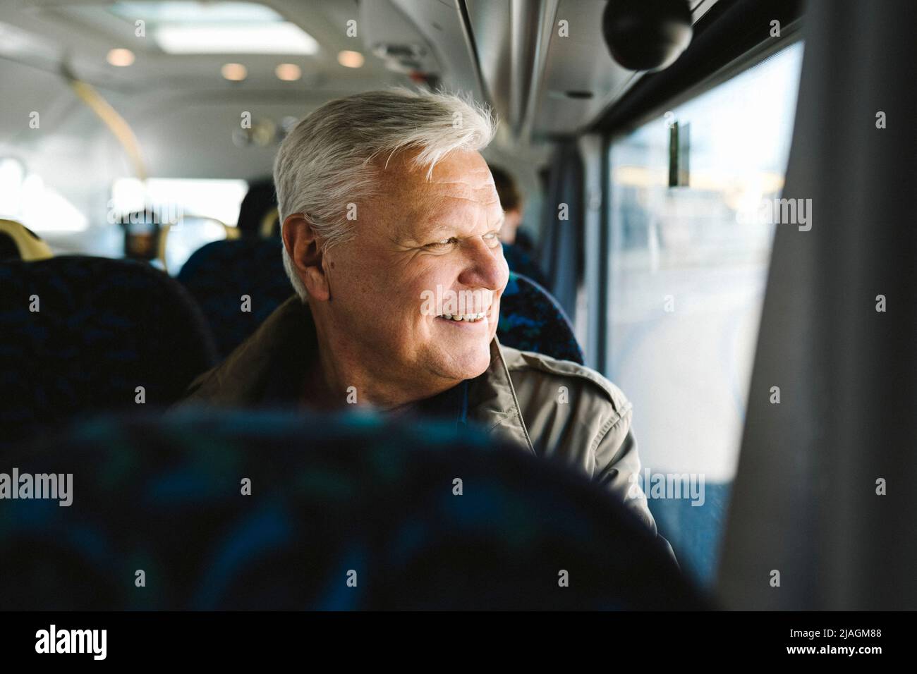 Happy businessman with gray hair looking through bus window Stock Photo ...