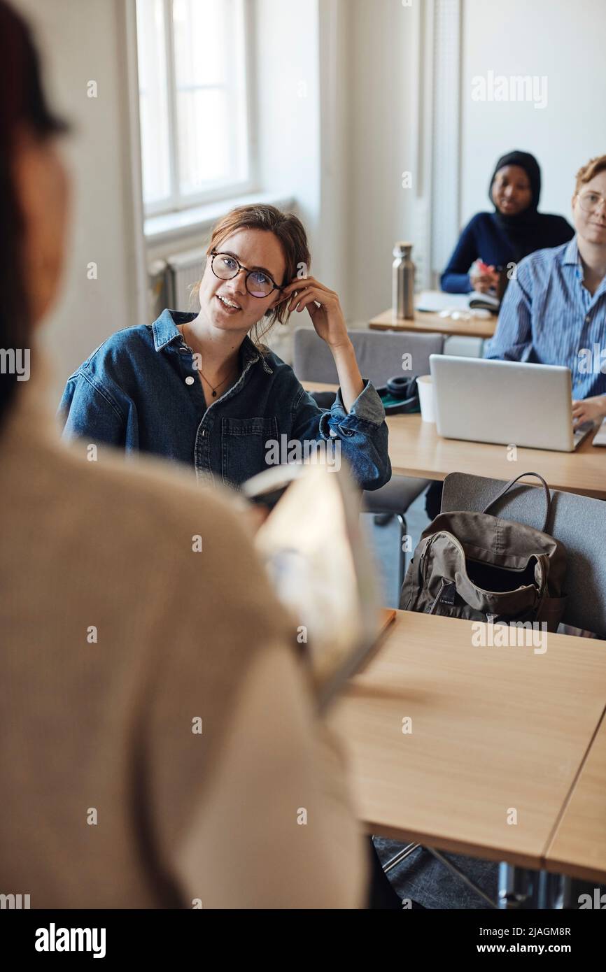 Female student talking to teacher during lecture in classroom Stock ...