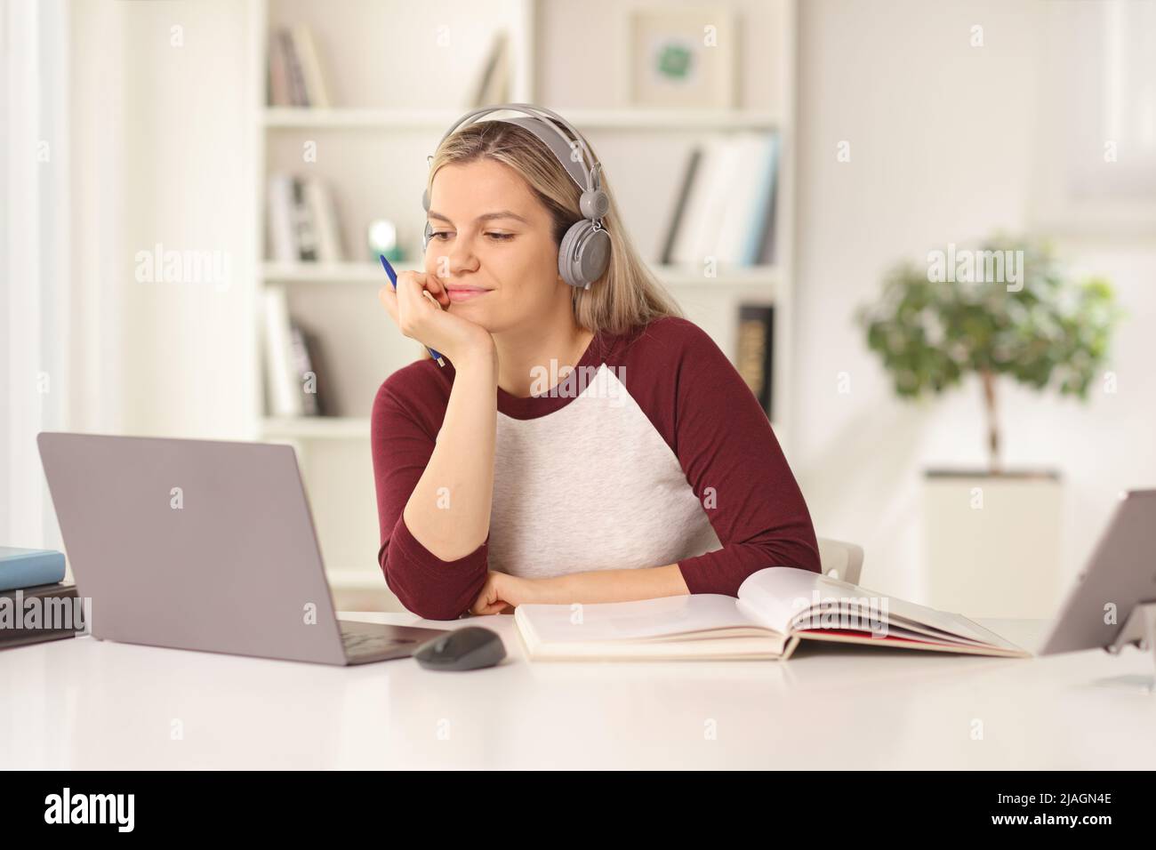 Female student studying in front of a laptop computer at home with ...