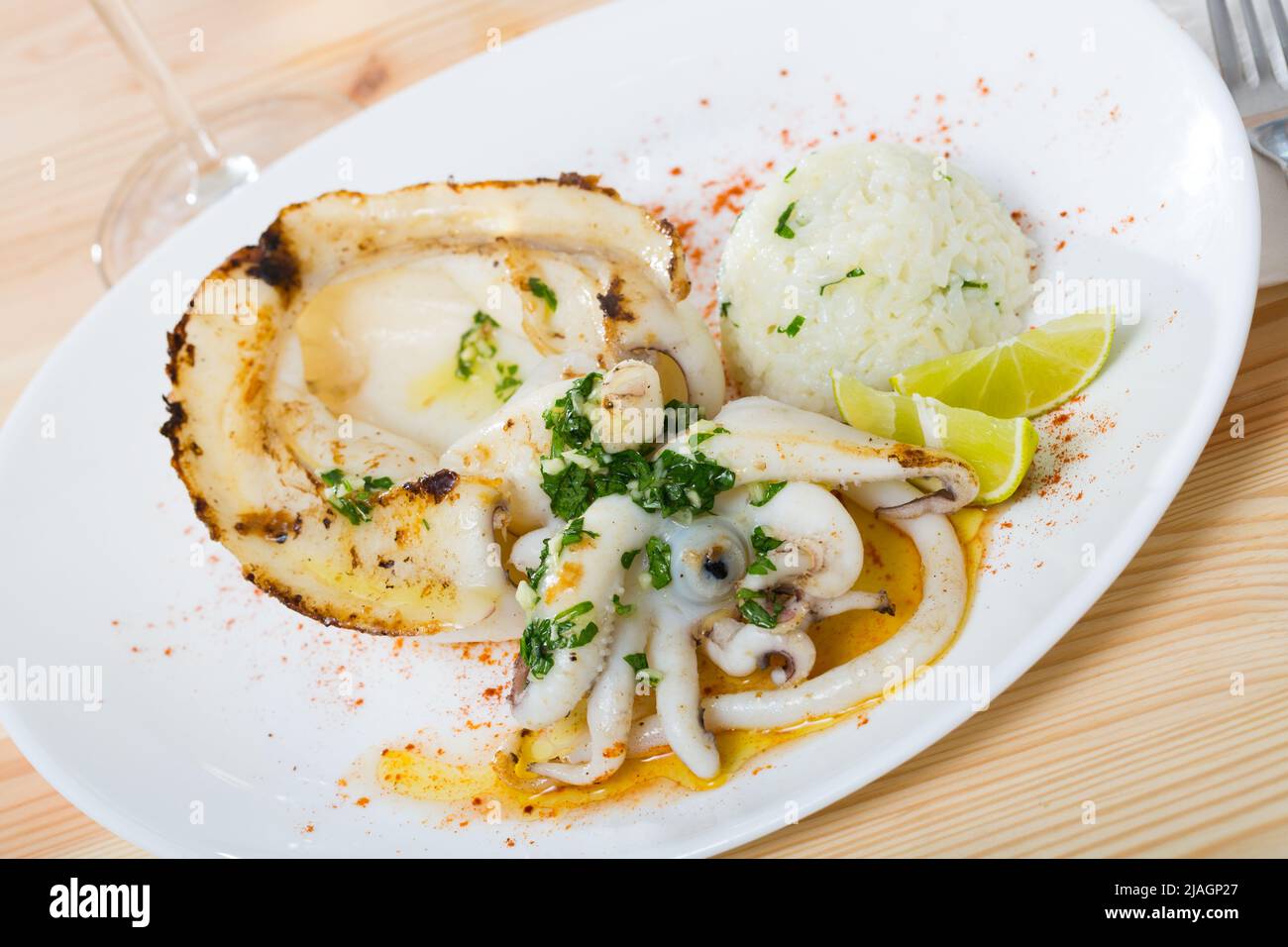 Baked cuttlefish with boiled rice Stock Photo - Alamy