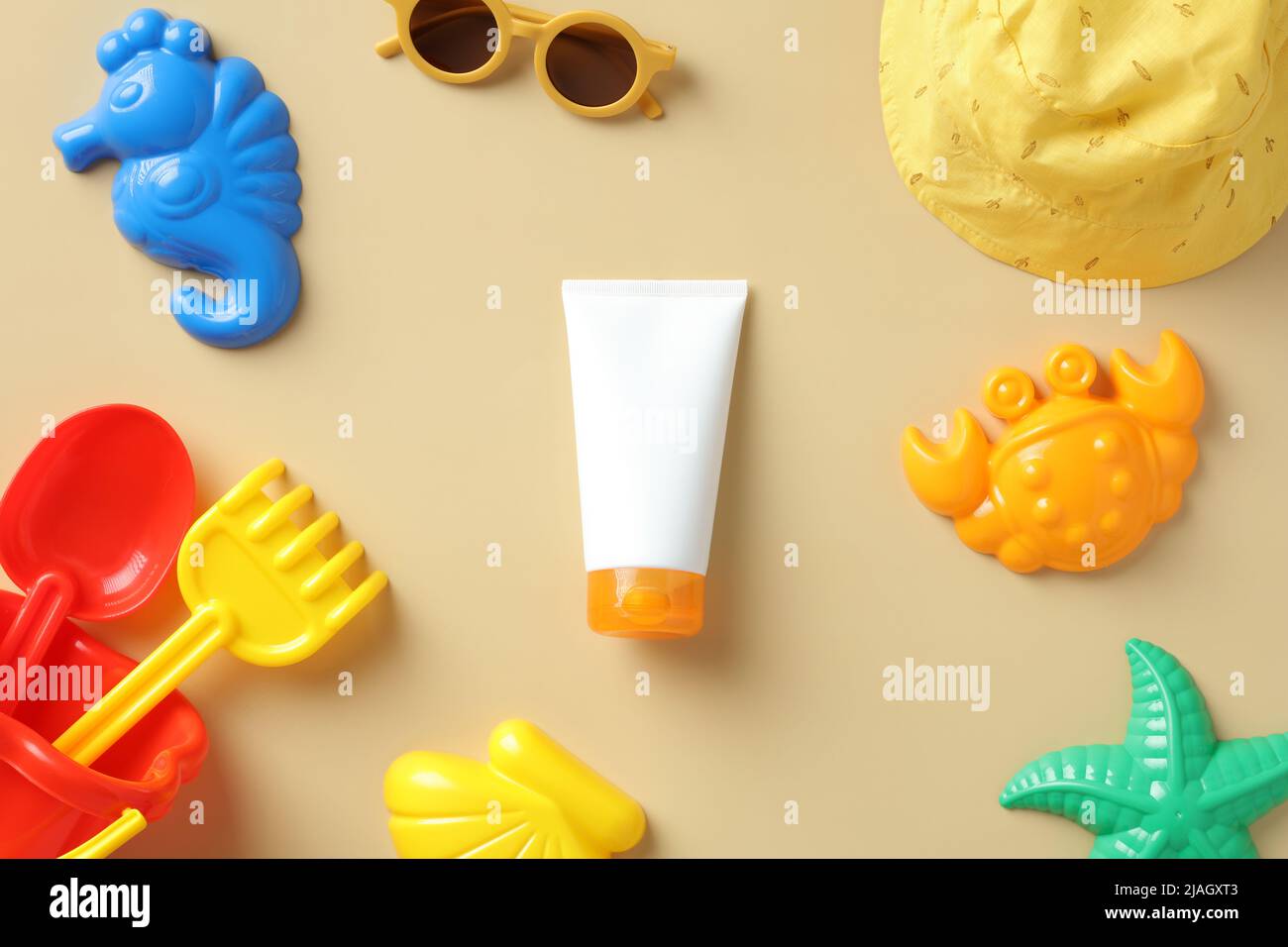 Flat lay composition with baby sunscreen lotion tube, sunglasses, sand ...