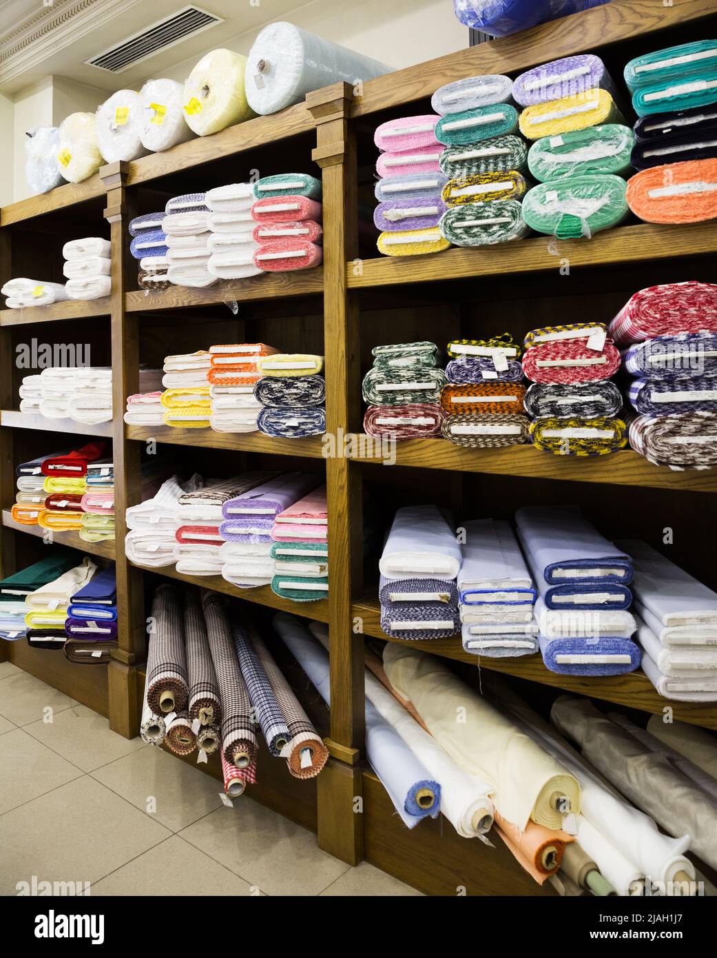 different fabric bolts exposed on shelves Stock Photo - Alamy