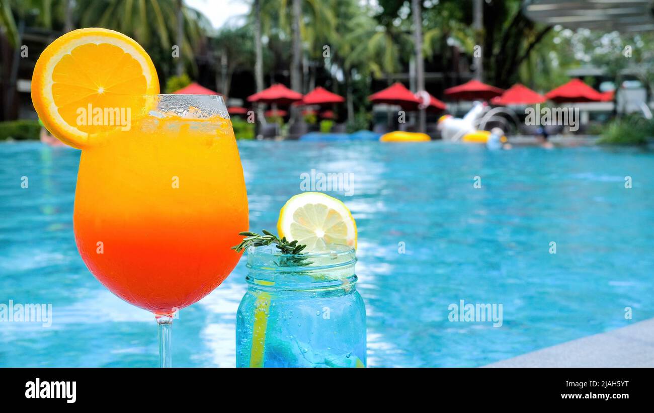 Summer vacation. Two glasses of tropical iced drinks on poolside with ...