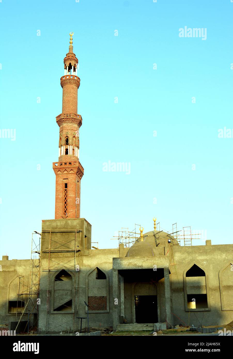 A new mosque under construction against the sunny blue sky with the ...