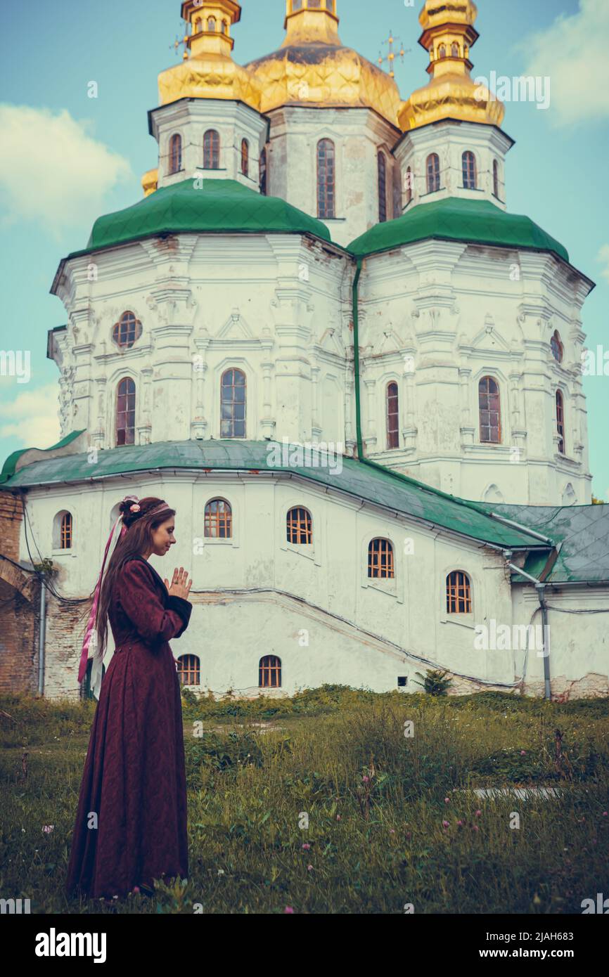 Portrait of brunette woman praying, dressed in historical Baroque ...