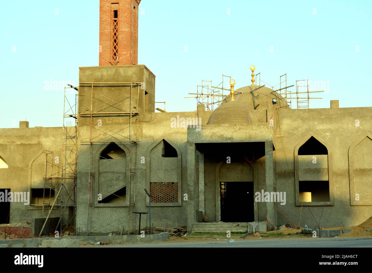 A new mosque under construction against the sunny blue sky with the ...