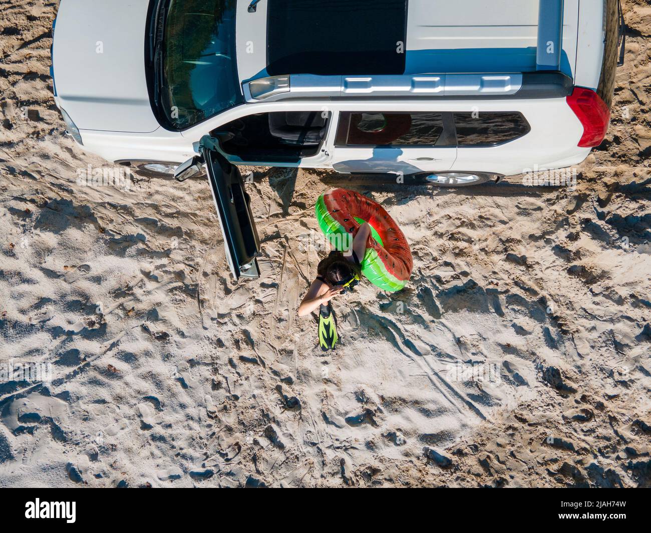 overhead top view happy woman getting out from the car in flippers with ...