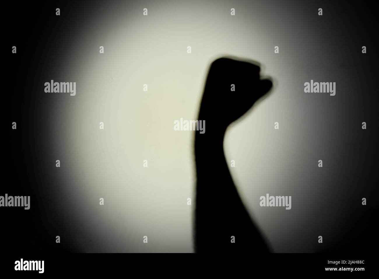 Shadow of a hand from the night light of a flashlight on a white wall ...