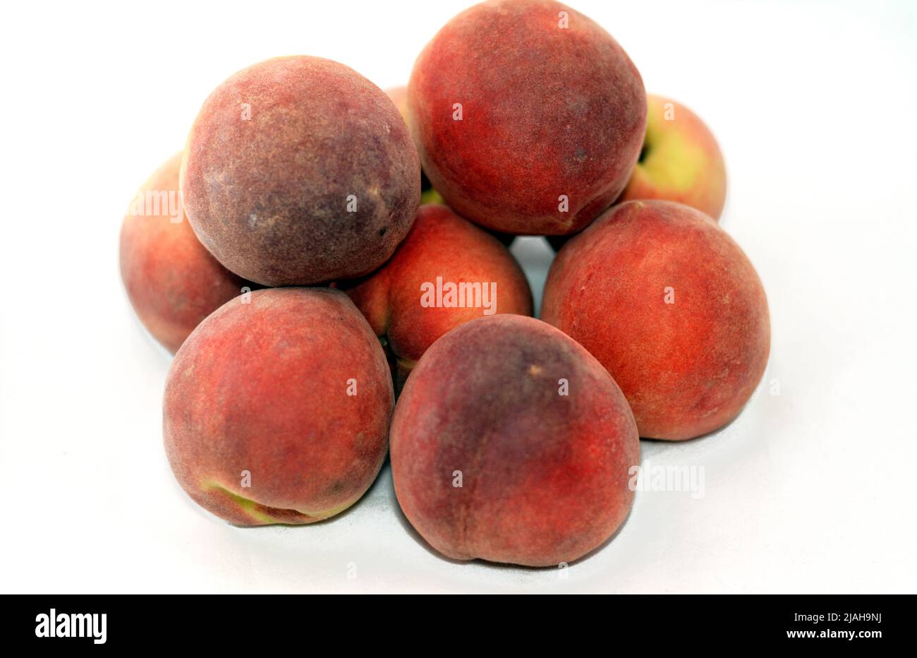 pile of fresh peach fruit isolated on white background, selective focus ...