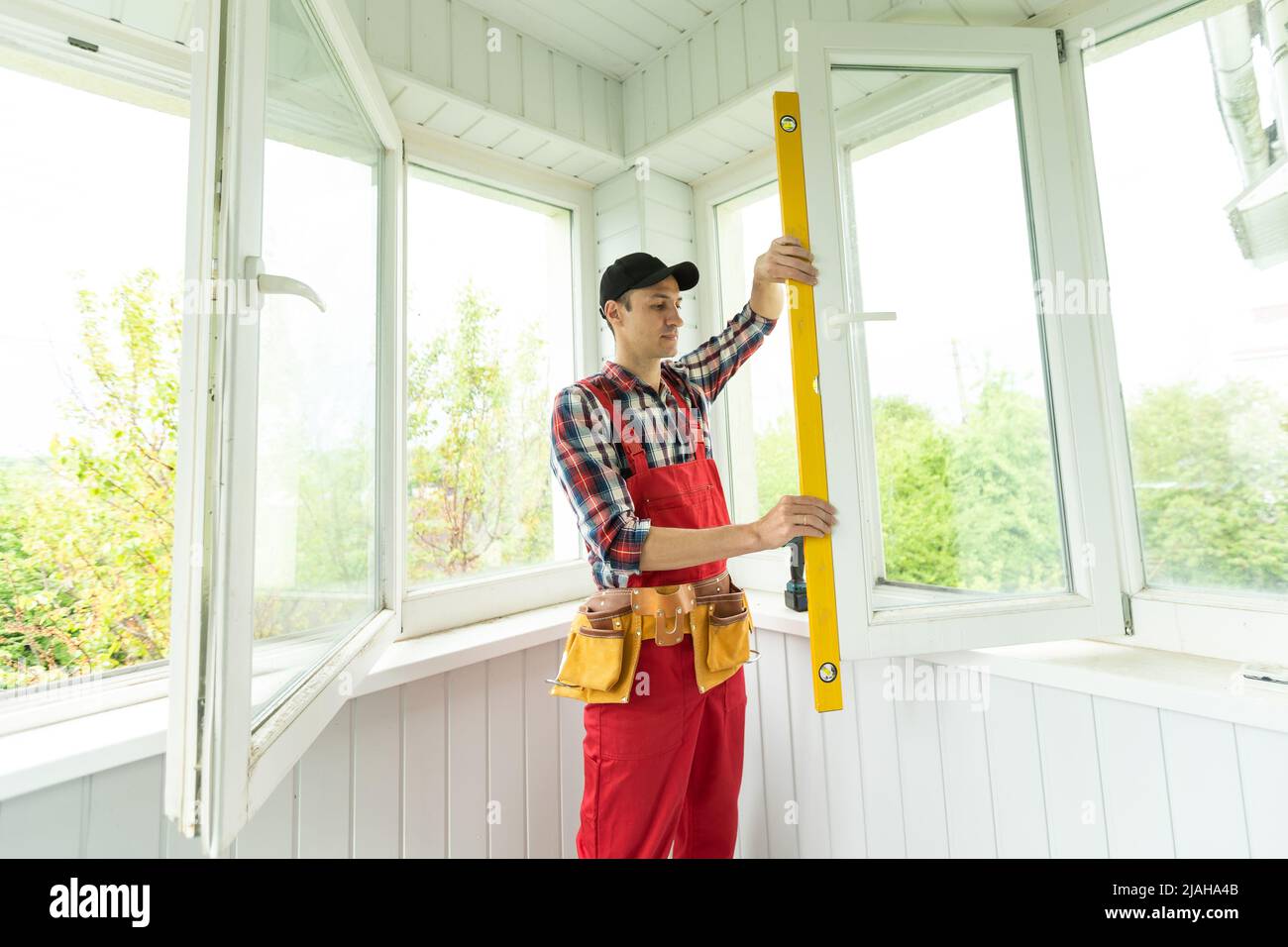 Man measuring window prior to installation of roller shutter outdoors ...