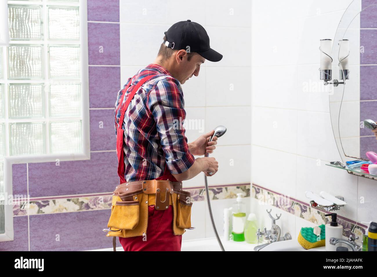 plumber at work in a bathroom, plumbing repair service, assemble and ...
