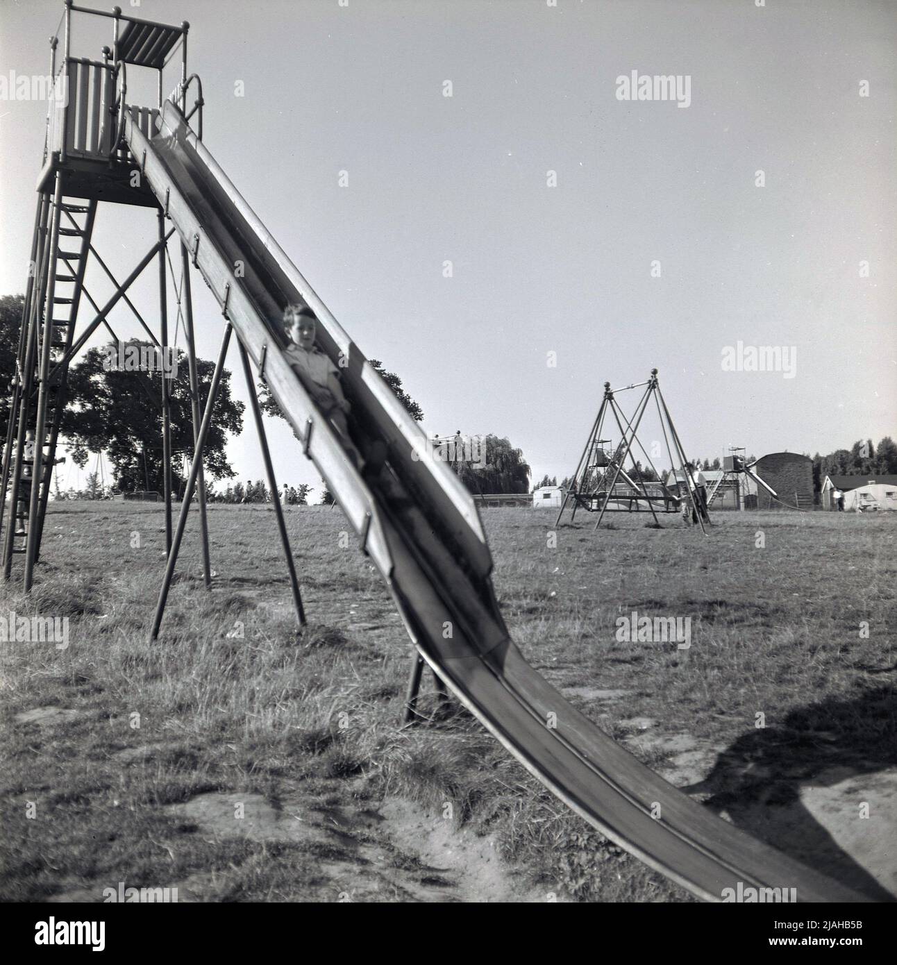 1950s, historical, outside in a large field, a playground area and a ...