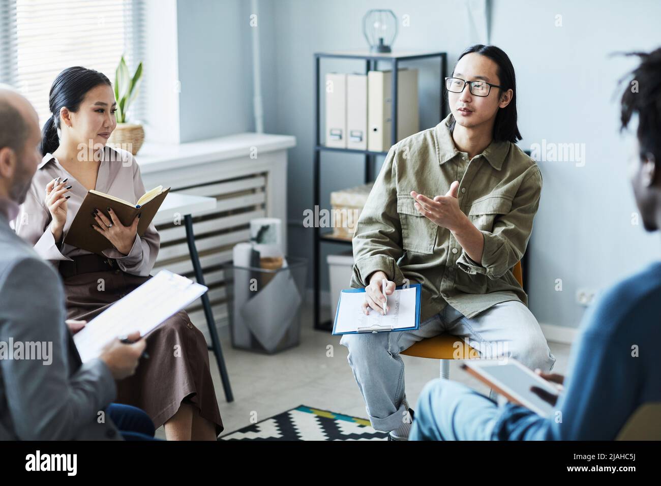Portrait of young Asian man asking audience during English lesson with ...