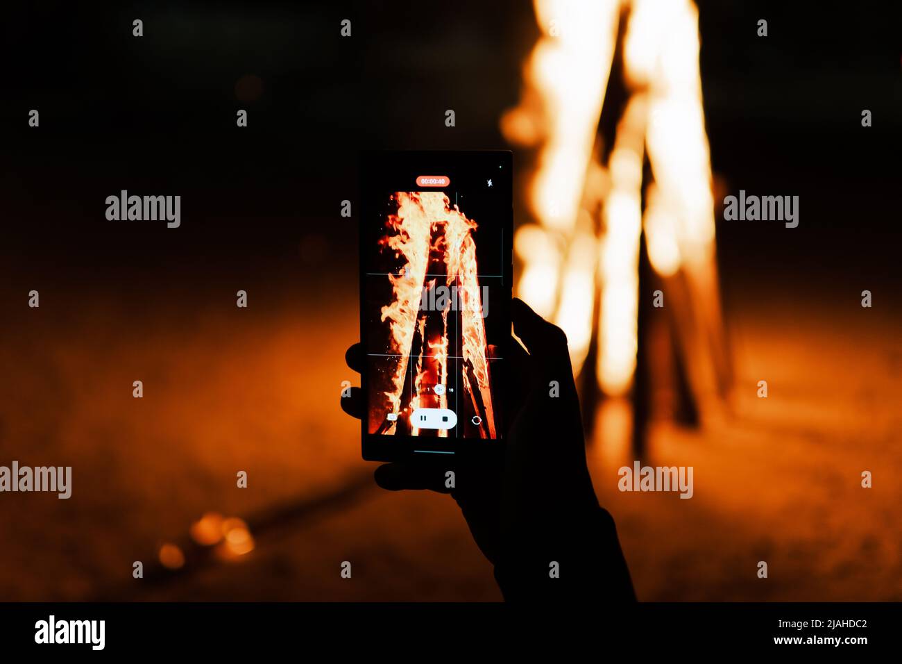 A campfire with sparks at night dark. Orange flame outdoor. Shooting ...