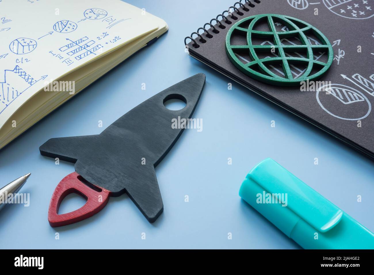 Rocket model as a symbol of new business and a green globe as ...