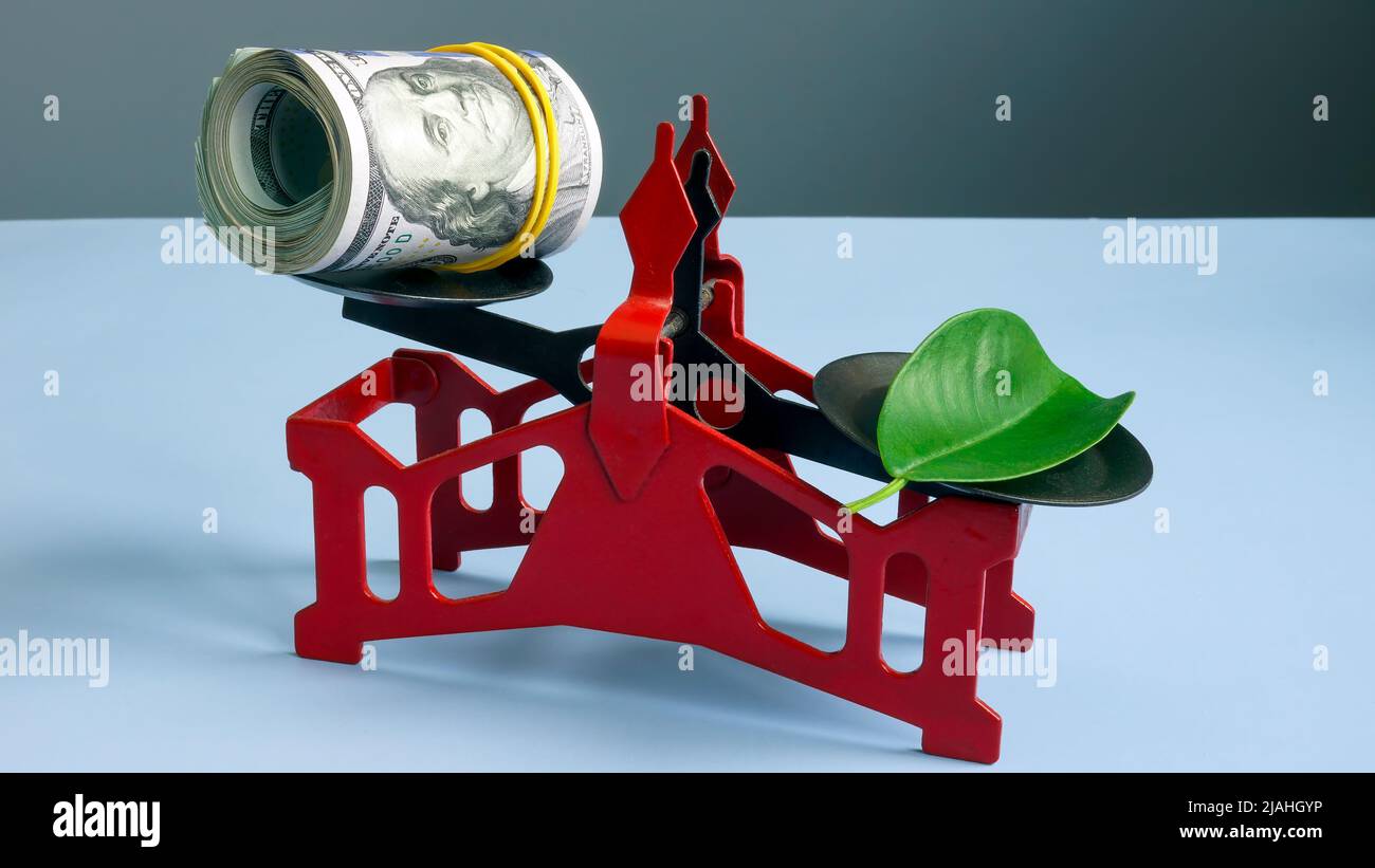 ESG concept. Scales with a bundle of money and a green leaf Stock Photo ...