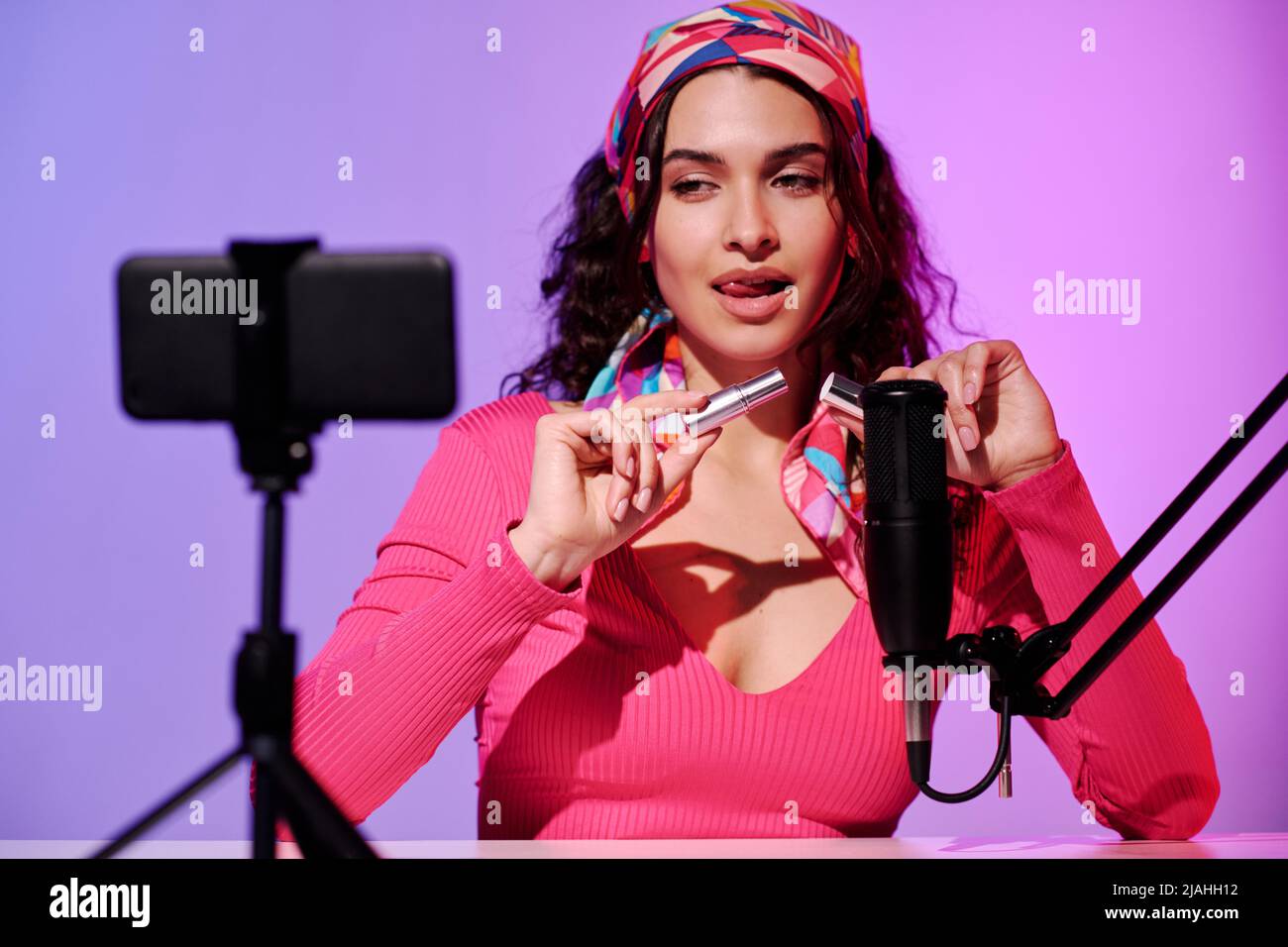 Self-confident attractive young woman sitting in front of smartphone ...