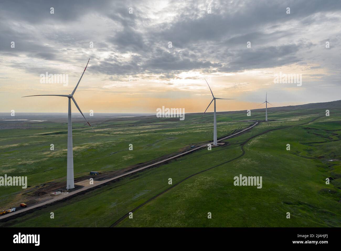 Wind turbine farm at sunset with dramatic sky. Producing alernative ...