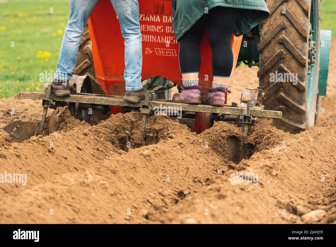Plowing and sowing the soil with a farm tractor in an agricultural ...