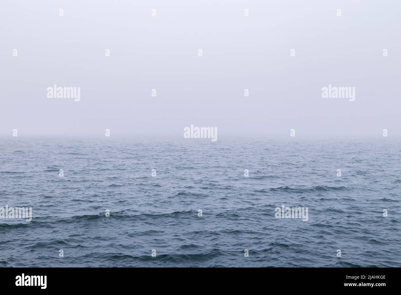 View of waves on the ocean with vanishing horizon on a foggy day. Copy ...