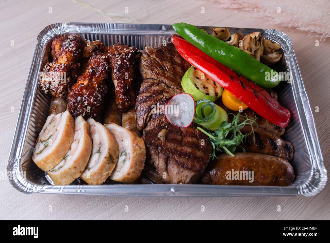 delivery of fresh grilled meat dishes in metal packaging Stock Photo ...