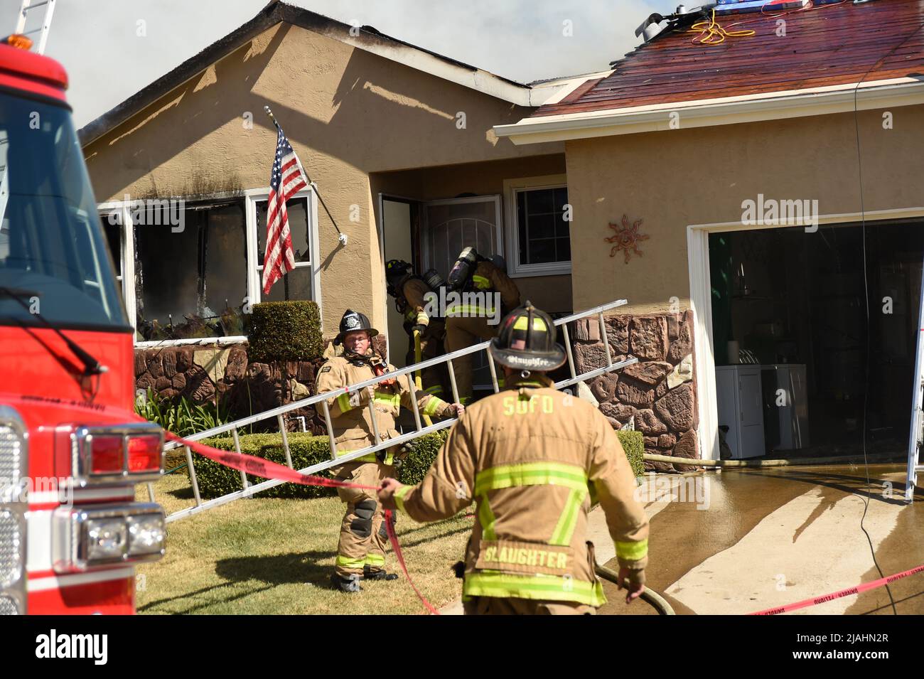 SDFD Firefighters positioning a ladder for roof ops at a structure fire ...