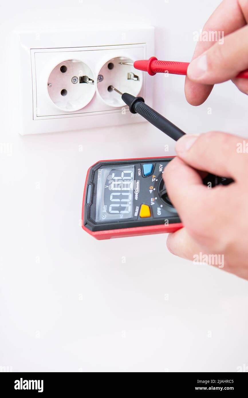 Measuring the voltage in the socket with a professional digital multimeter. Profession ...