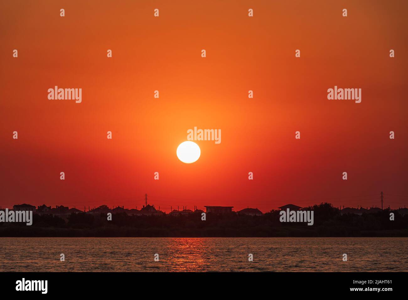The sun goes down over a lake. Dramatic Sunset Sky Stock Photo - Alamy