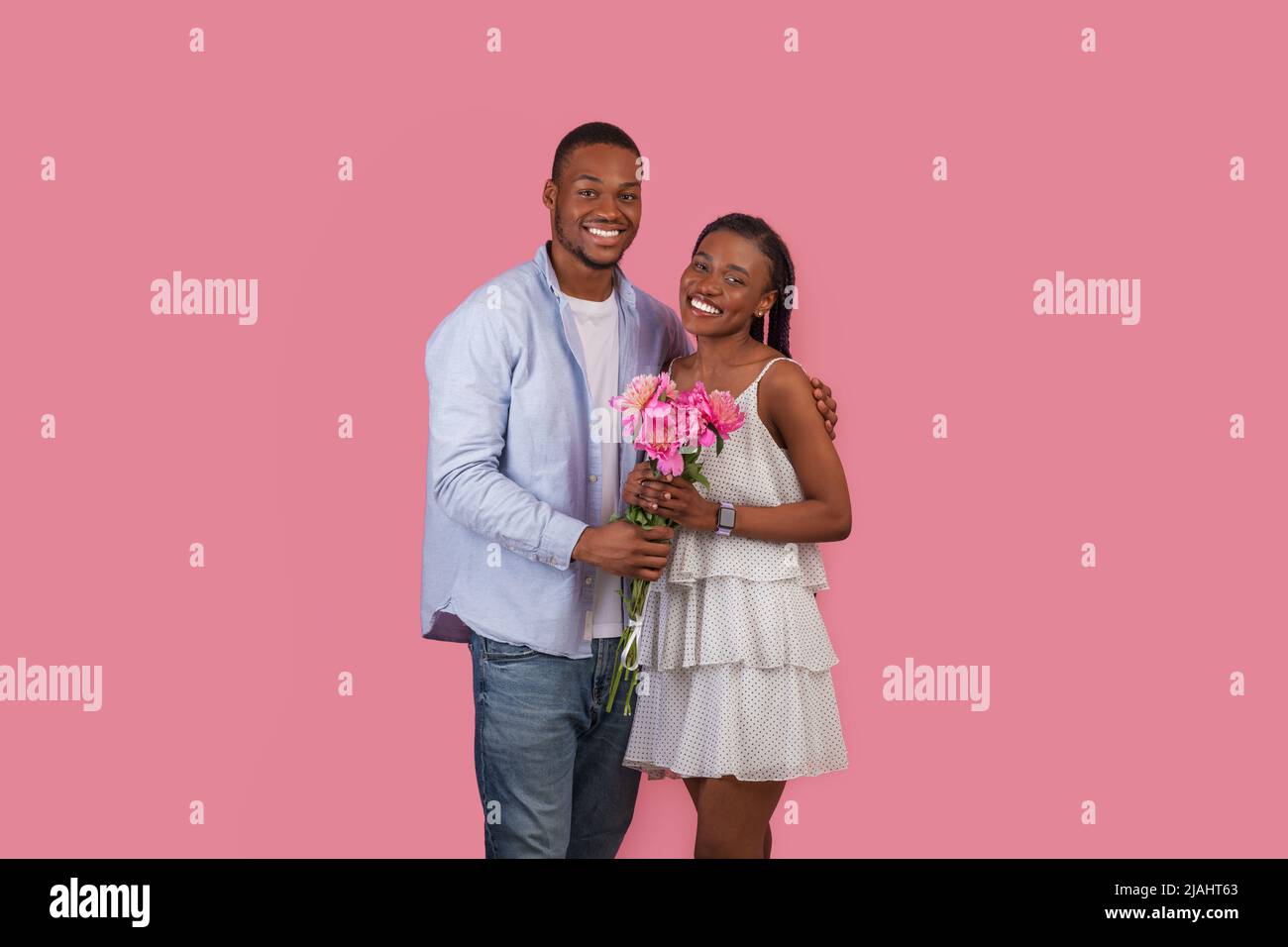 Happy black man making surprise for woman giving flowers Stock Photo ...