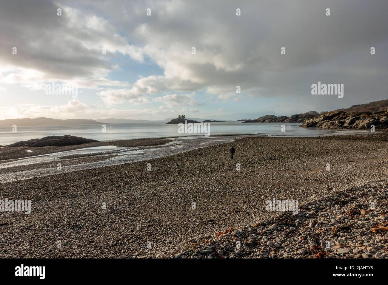 Scottish landscape - person walking on pebble beach at the stunning ...