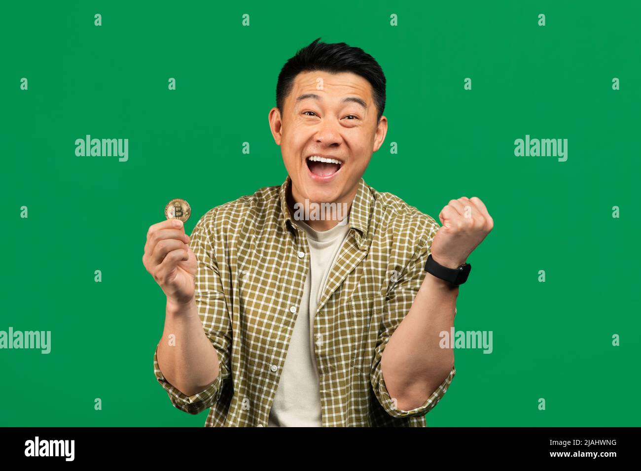 Joyful asian mature man showing yes gesture and holding golden bitcoin ...