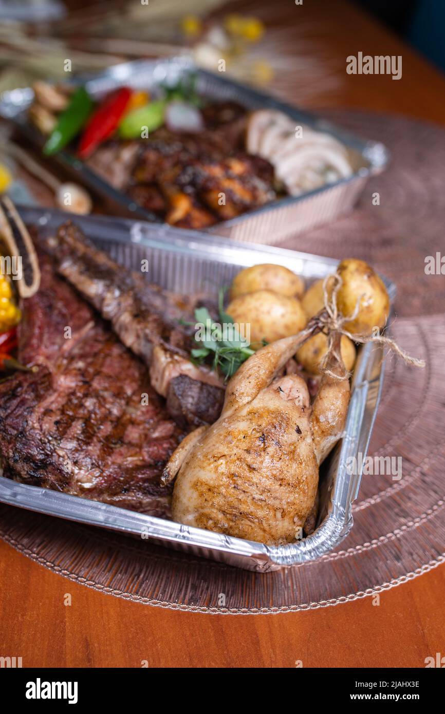 delivery of fresh grilled meat dishes in metal packaging Stock Photo ...